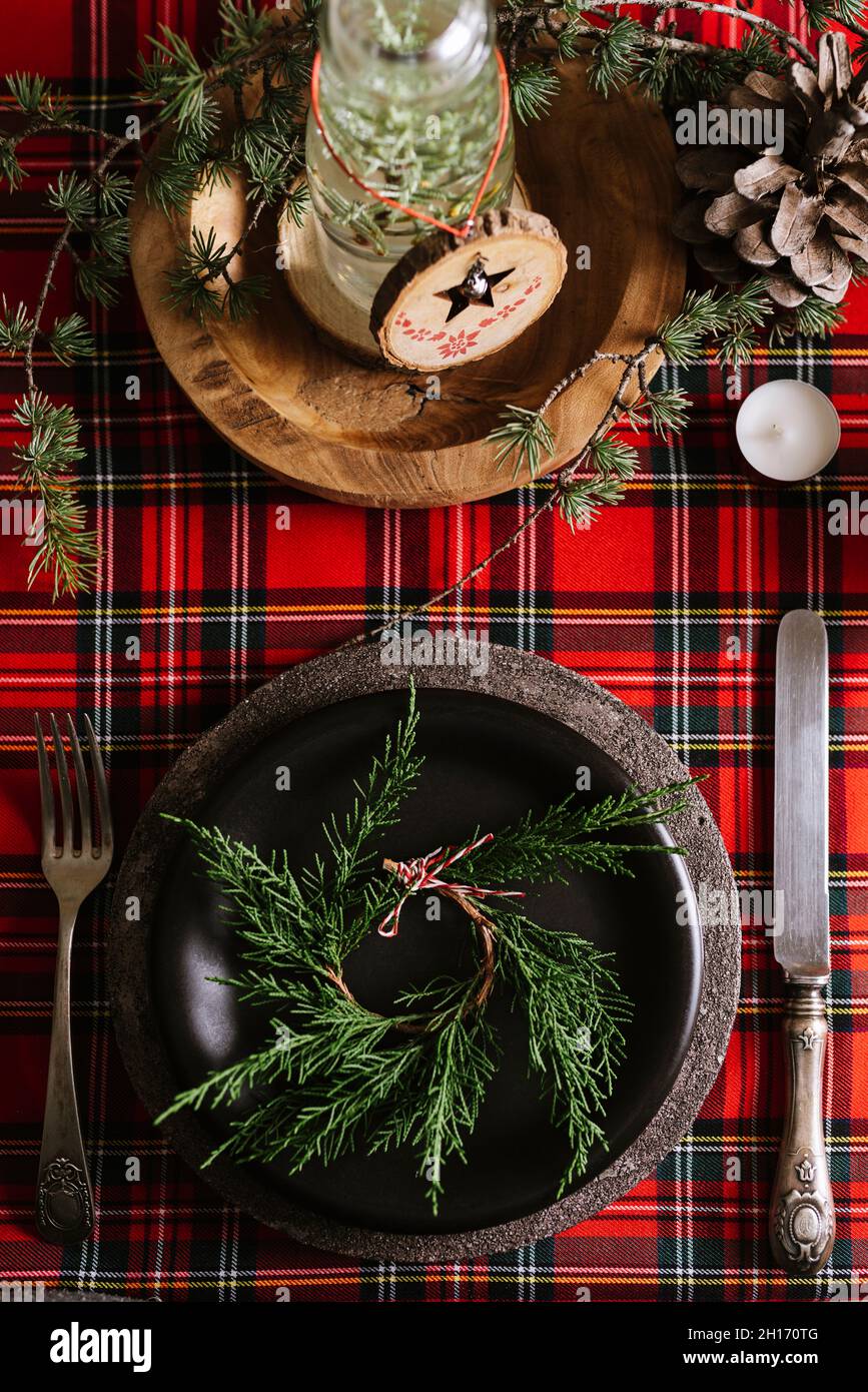 From above Christmas table setting with wreath on ceramic plate with ...