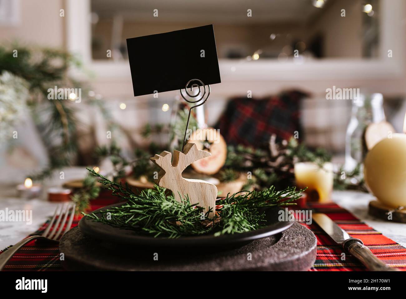 Christmas table setting with reindeer of wood with blank name card on ...