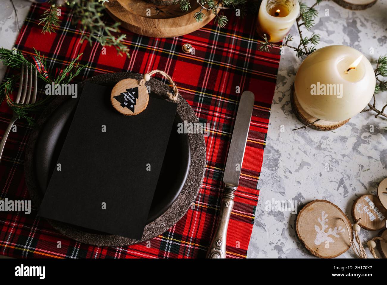 Top view of christmas table setting with empty menu on ceramic plate ...