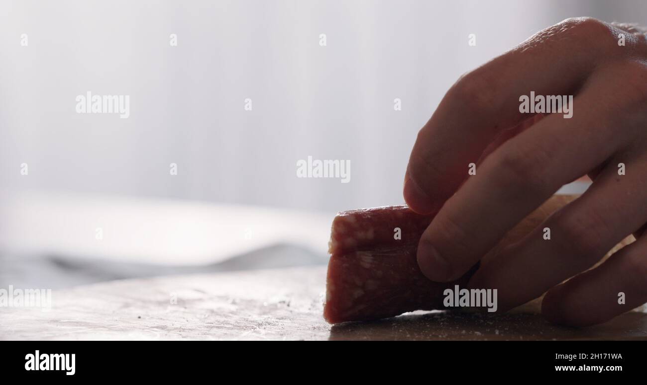 man slicing salami on olive board, wide photo Stock Photo - Alamy
