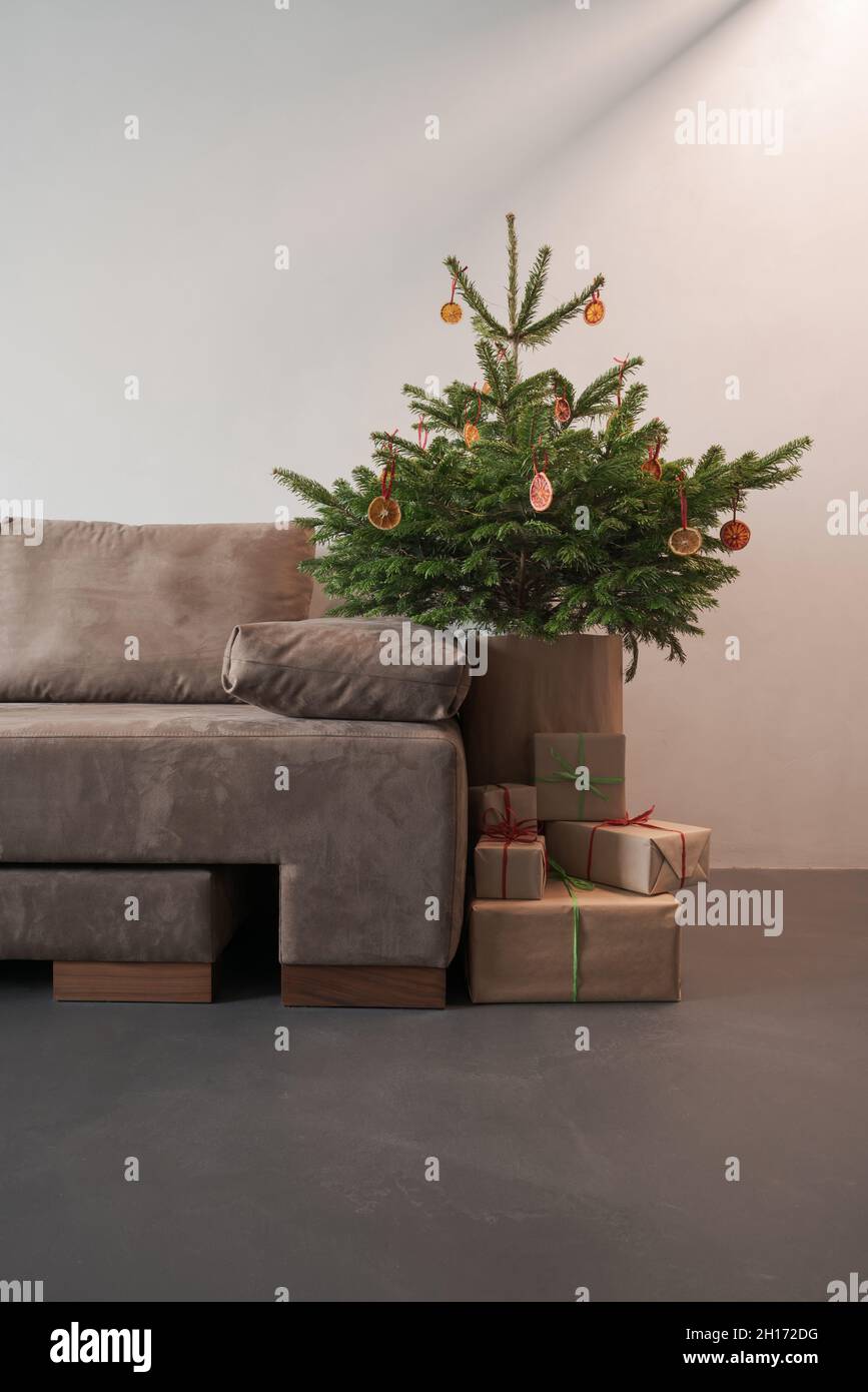 Small christmas tree with natural decorations and presents indoor near ...