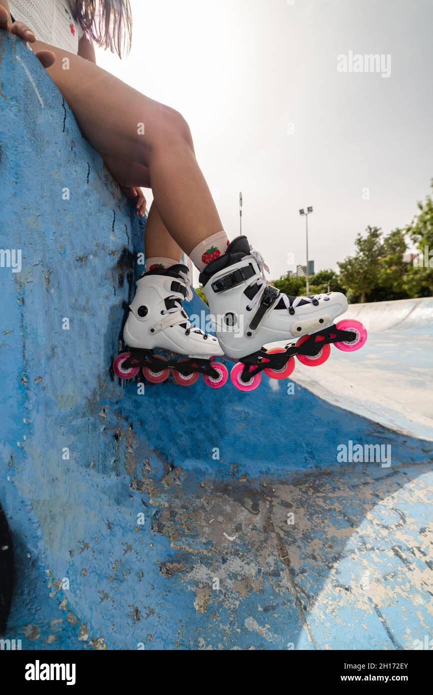 Crop anonymous female legs in white roller blades with pink wheels ...