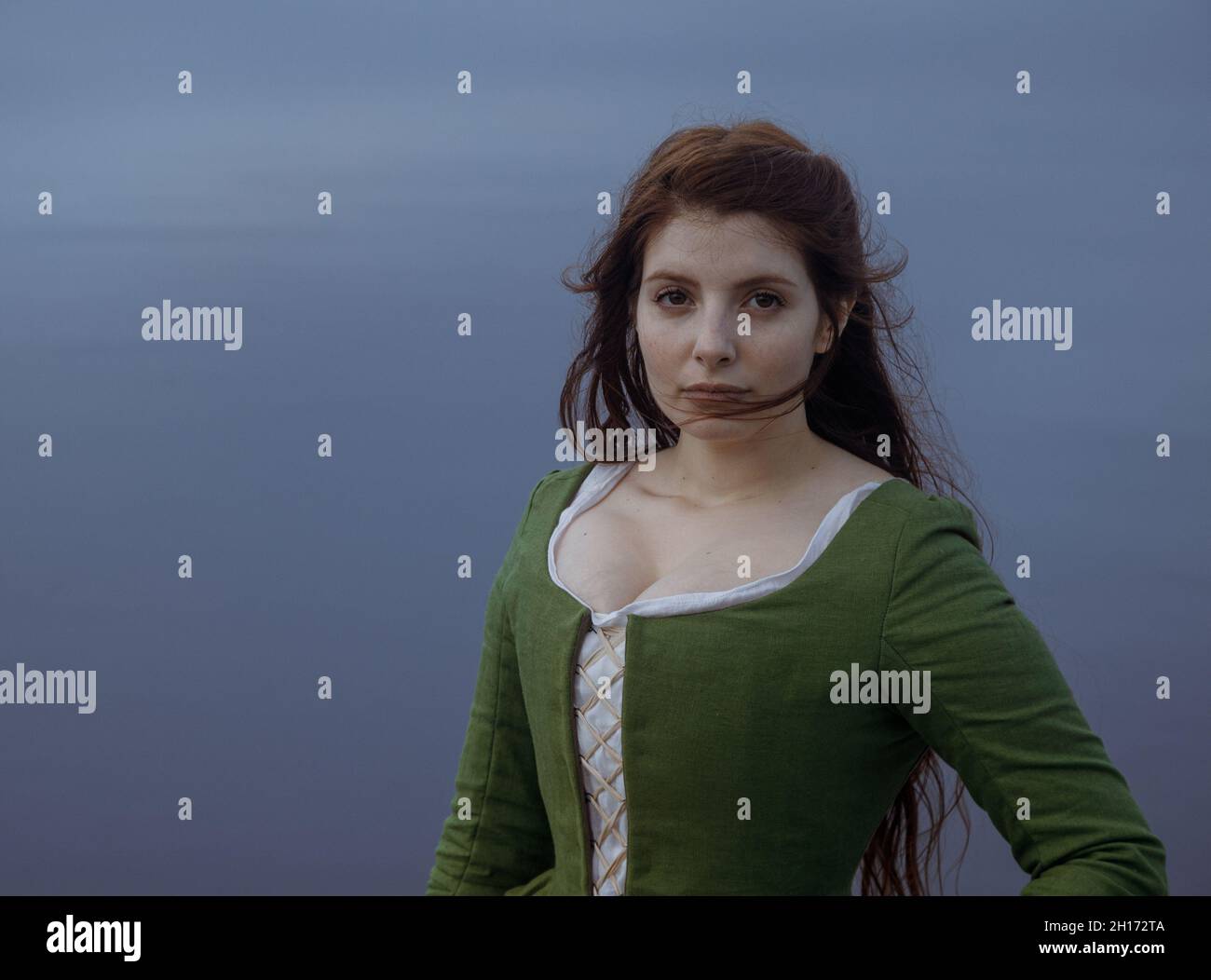 Portrait of dreamy female in old fashioned clothes in misty weather ...