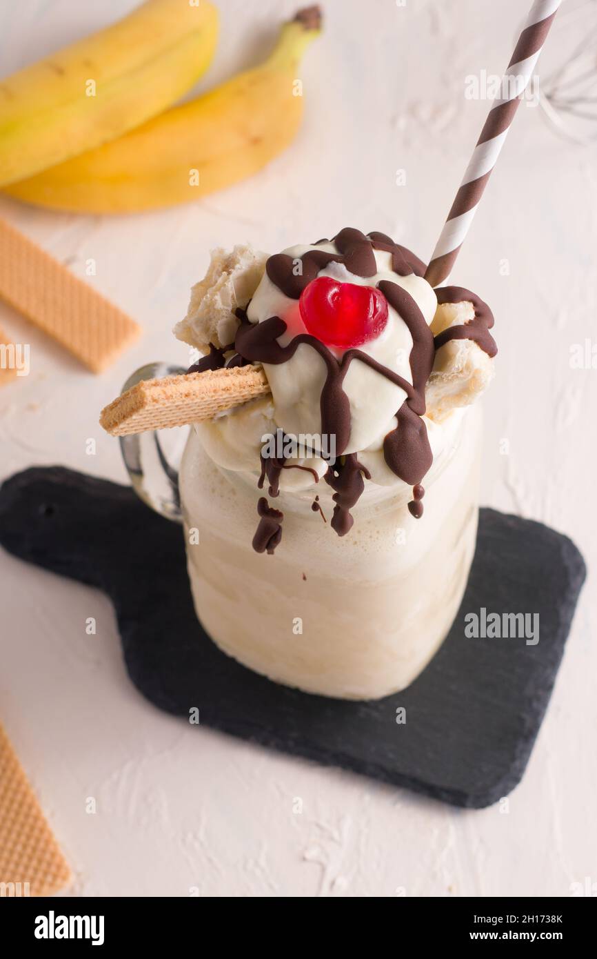 From above of glass jar of sweet banana split milkshake topped with ...