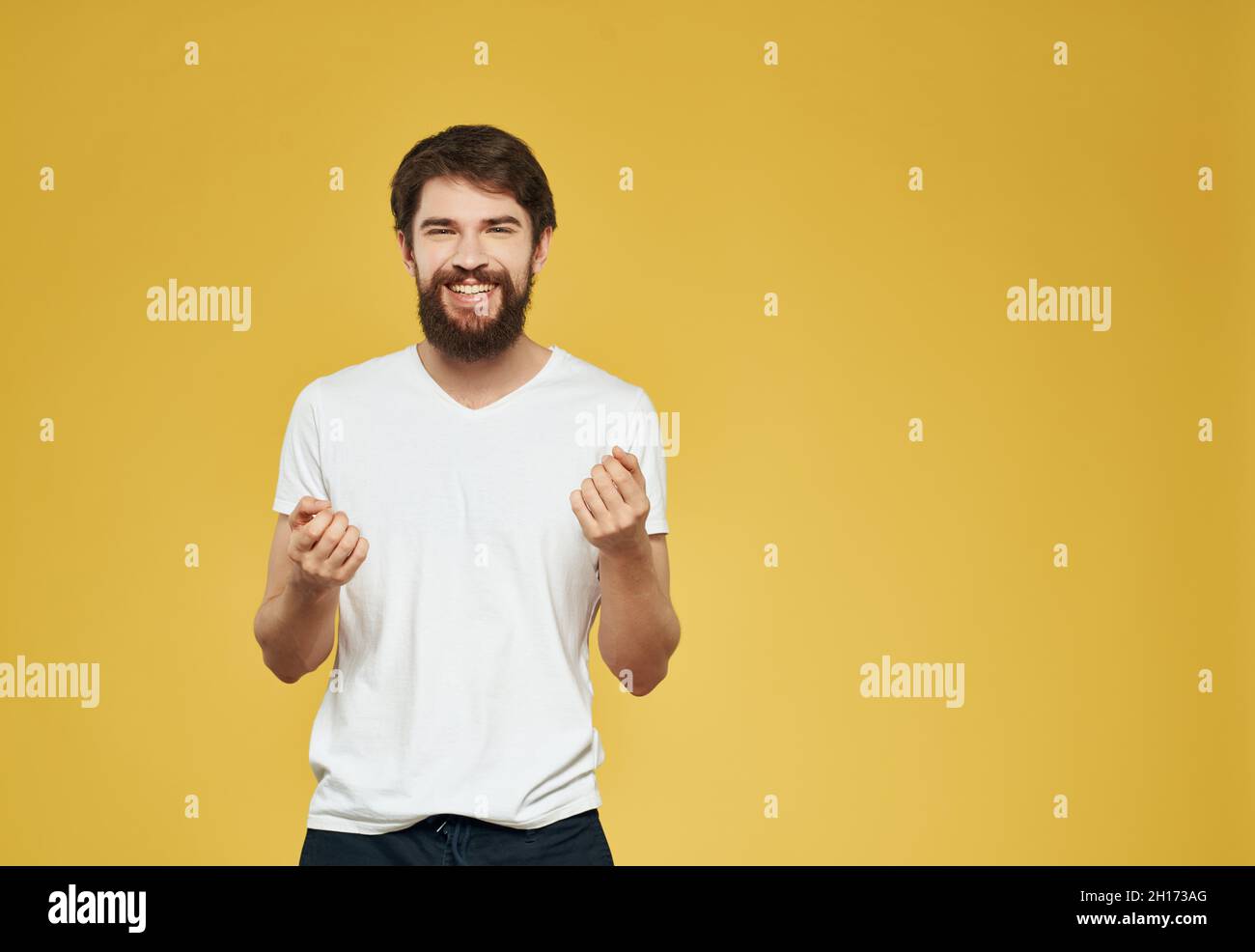 Man in a white t-shirt hand gestures anger yellow background Stock ...