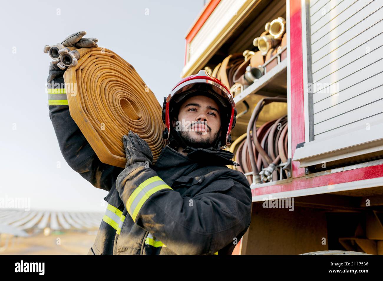 Firefighter carrying hose on shoulder hi-res stock photography and ...
