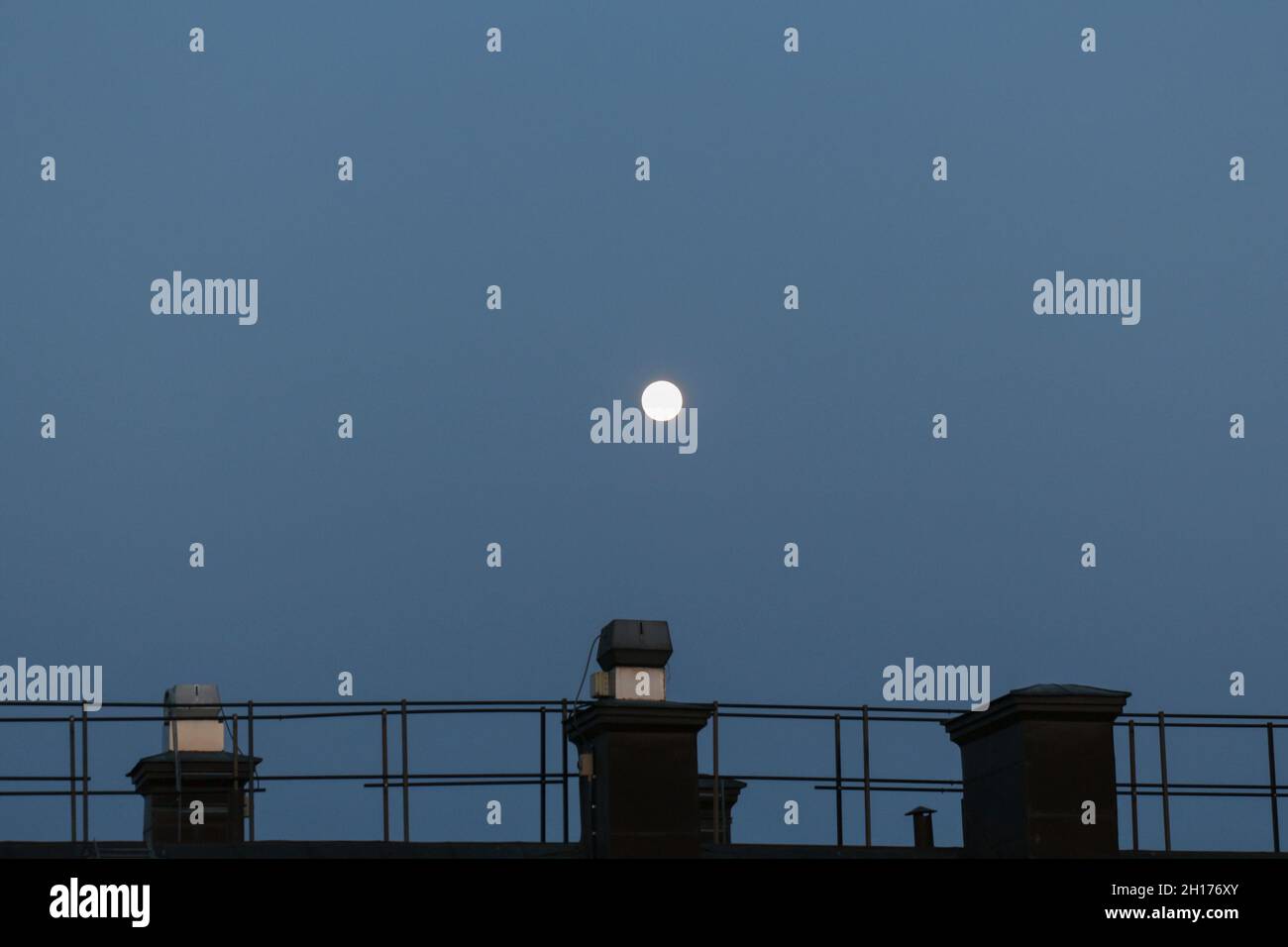 The view of the moon above the roof at night Stock Photo - Alamy