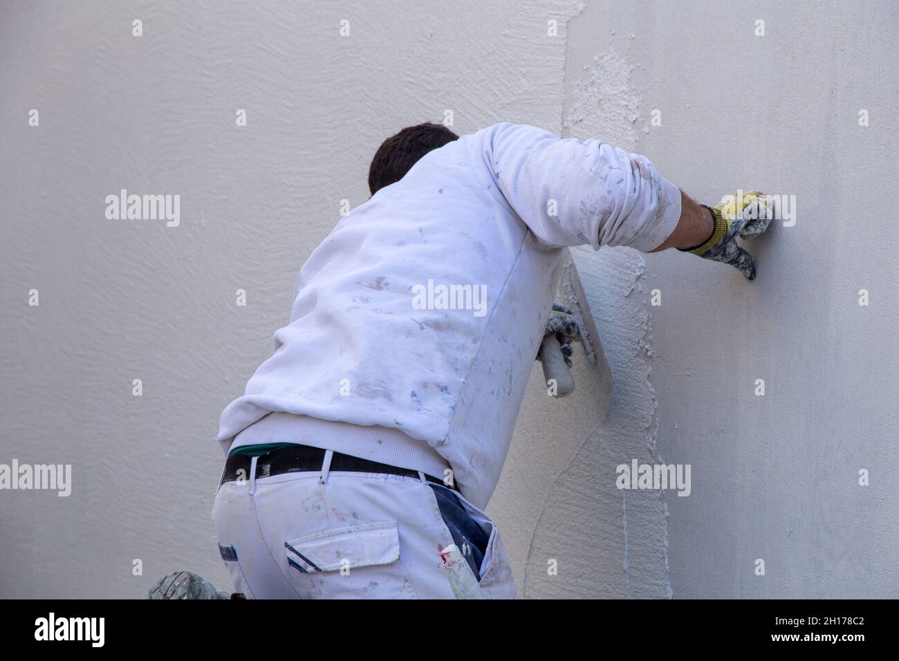 Plasterers plaster the facade of a new building Stock Photo - Alamy