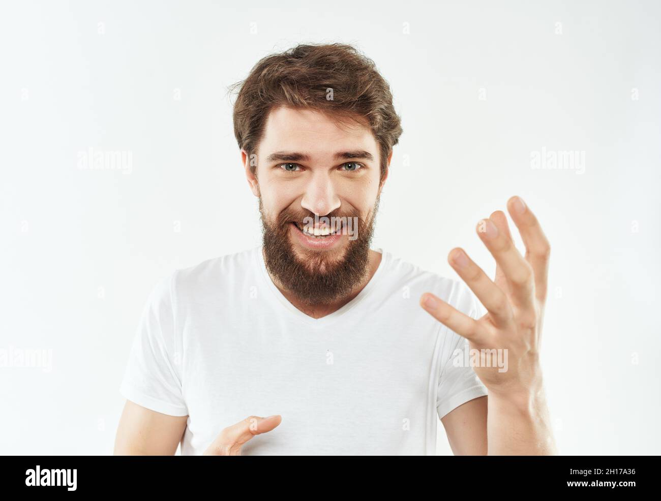 emotional bearded man gesturing with his hands anger light background ...