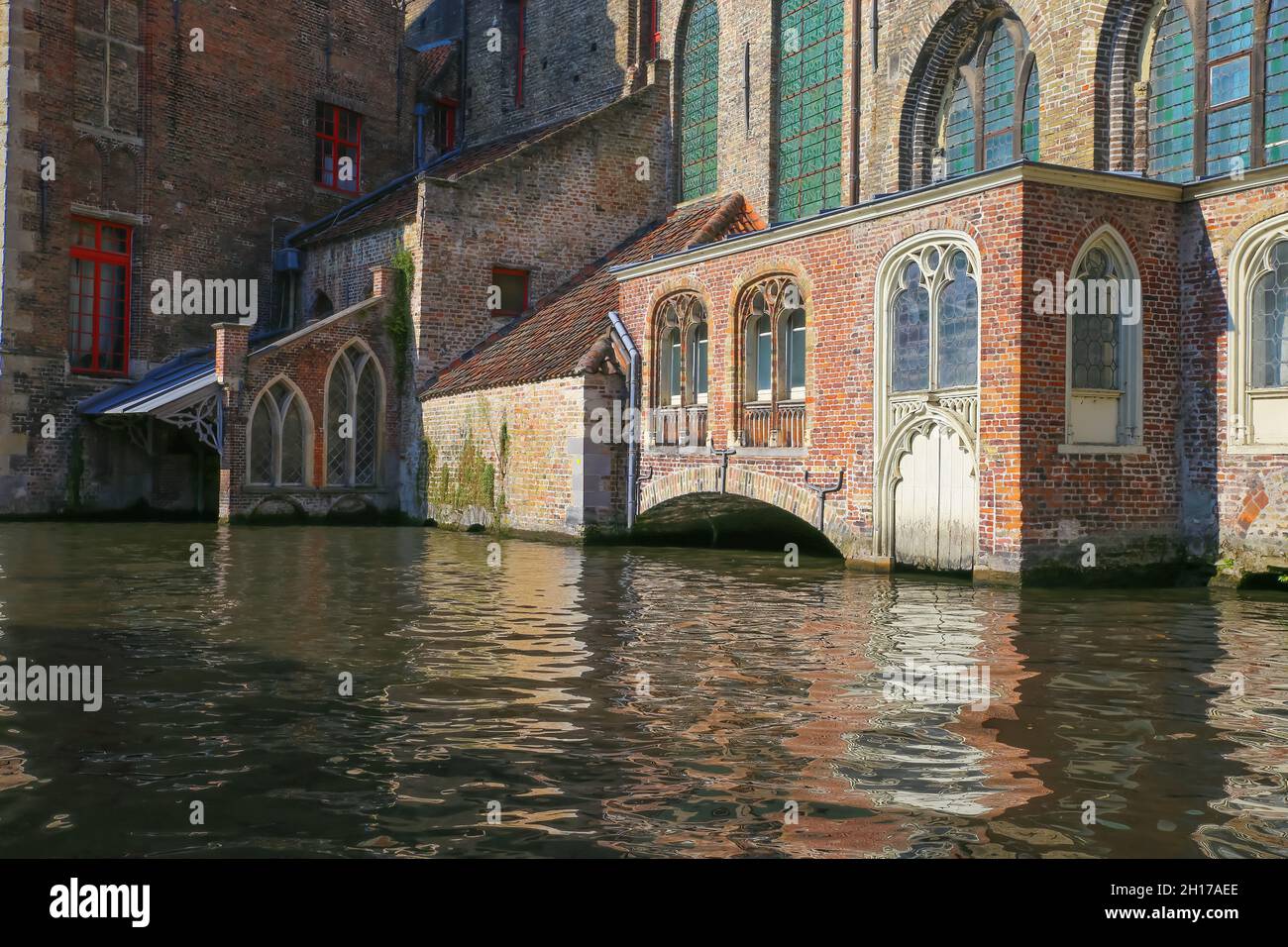 View over water canal on medieval brick gothic hospital building wall ...