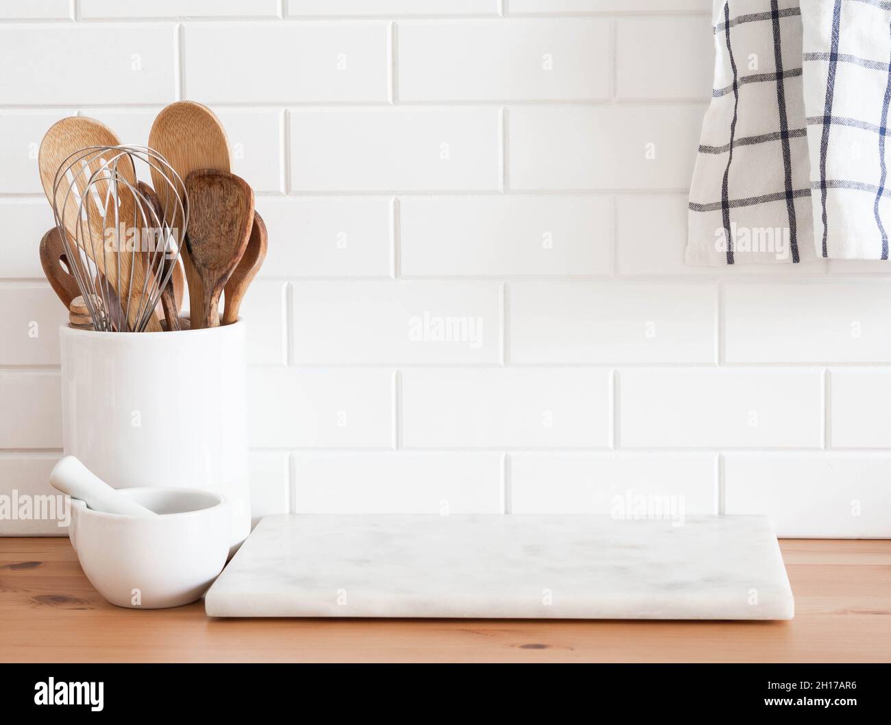 Stylish white kitchen background with kitchen utensils standing on wood ...