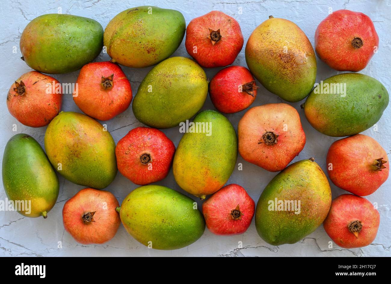 A top view of mango and pomegranates on a gray background Stock Photo ...