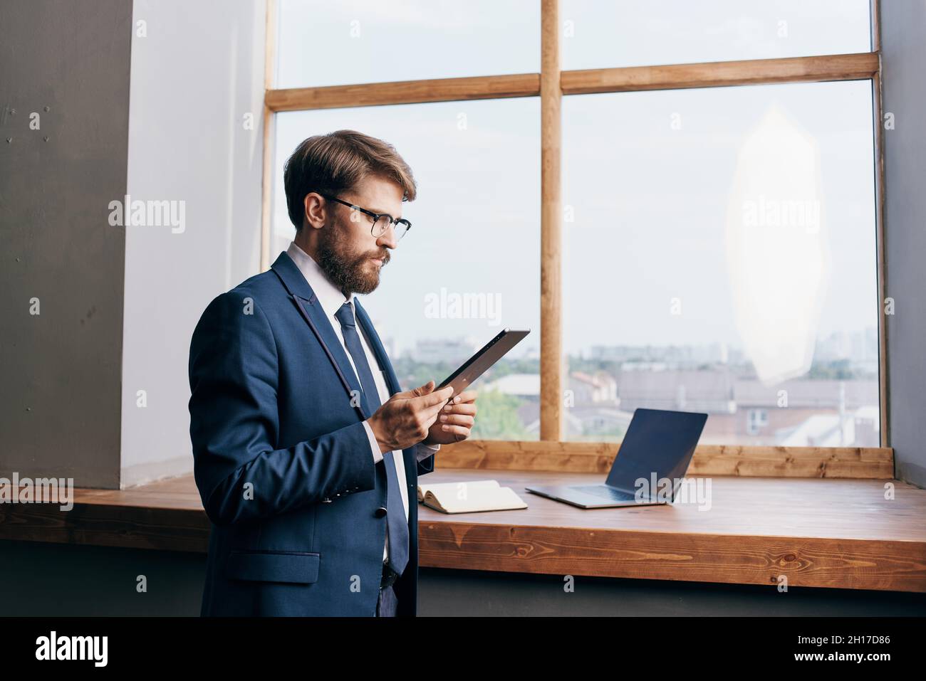 entrepreneur near the window with a tablet self-confidence Stock Photo ...