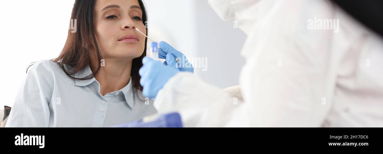 Doctor in protective anti-plague overalls taking pcr swab from nose of ...