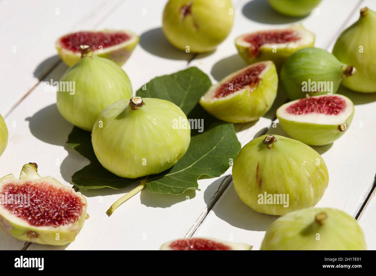 Fresh green figs with leaves on white wooden table Stock Photo - Alamy