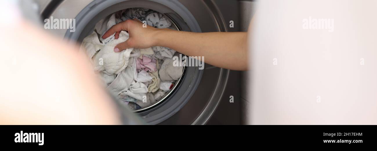 Female hand pulling out clean linen from washing machine closeup Stock ...