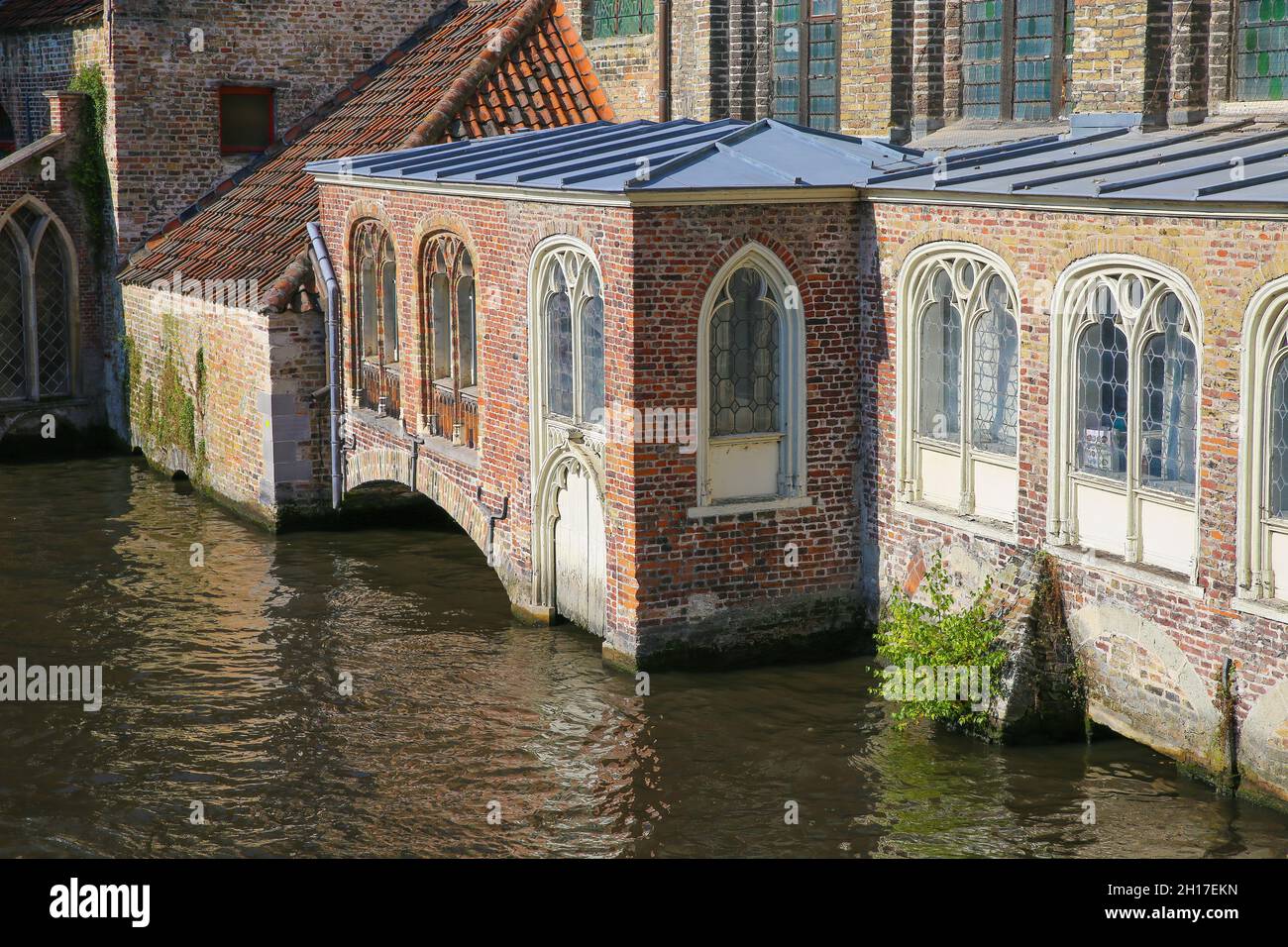 View over water canal on medieval brick gothic hospital building wall ...
