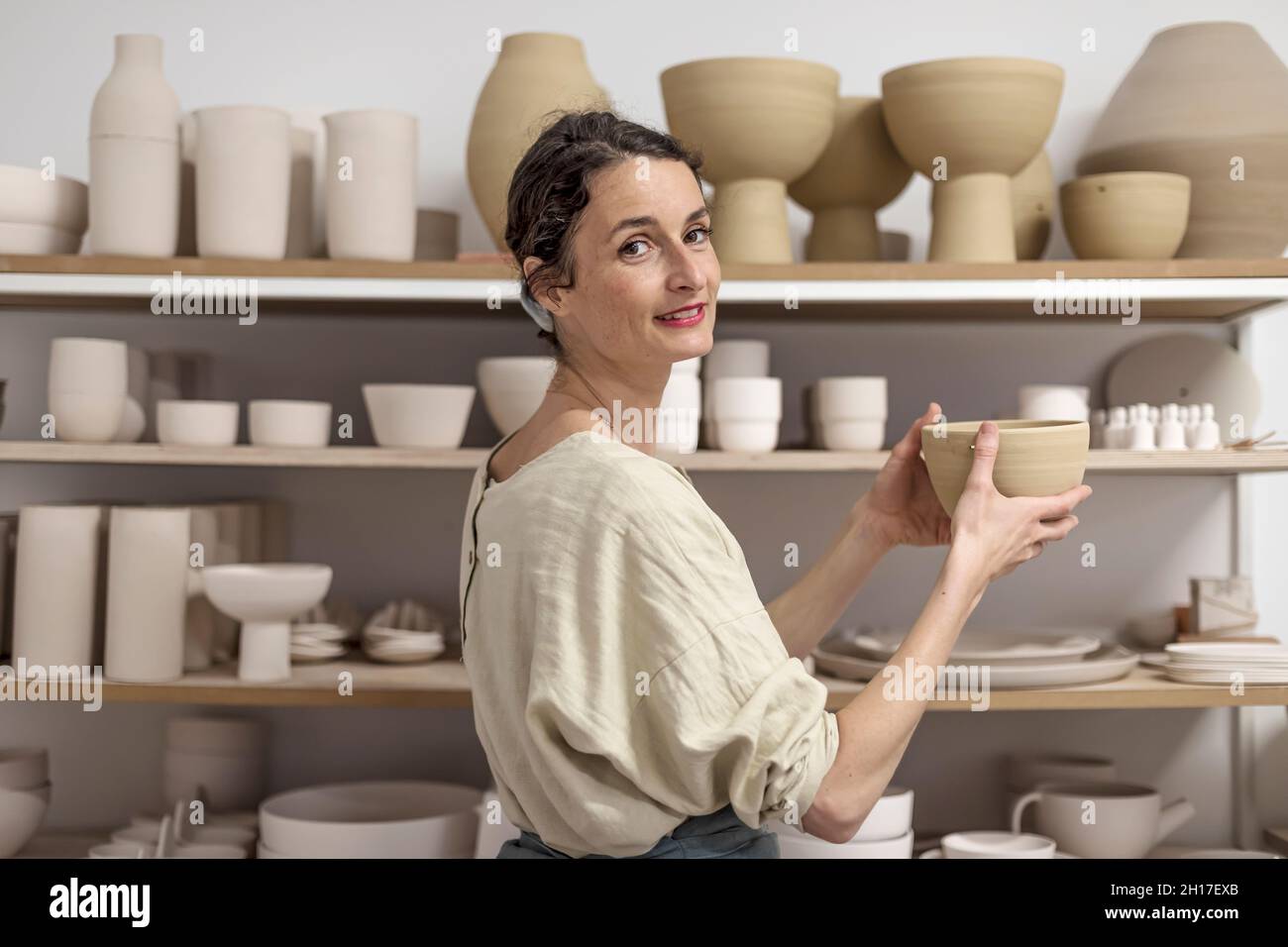 Ceramist woman holding a potter in her studio Stock Photo - Alamy