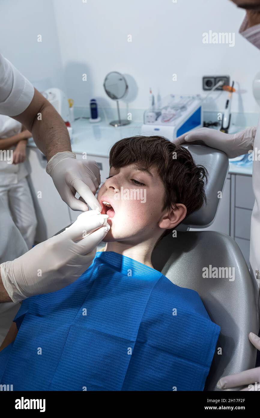 Dentist examining little boy's teeth in clinic Stock Photo - Alamy