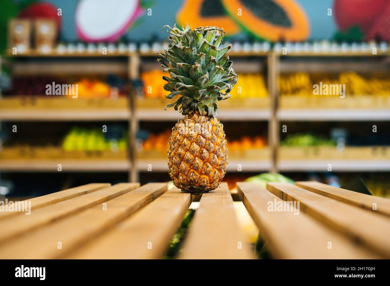Close-up front view of fresh juicy pineapple standing on wooden pallet ...