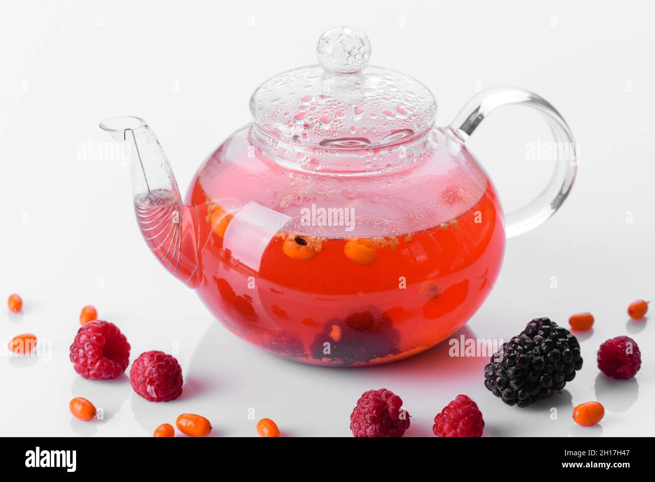 Delicious tea of berries and fruits in a beautiful glass teapot on a ...
