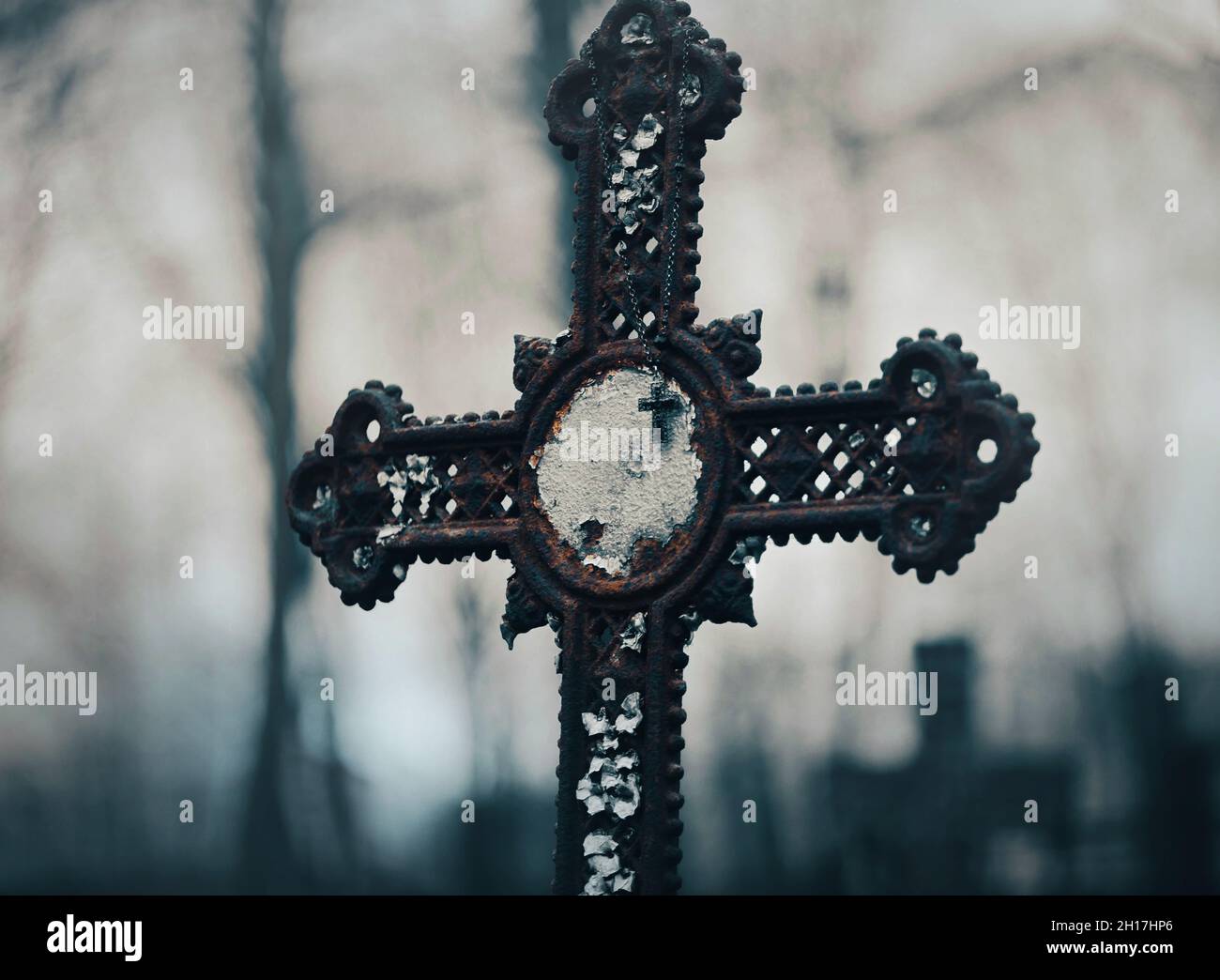 There is an old rusty cross in the cemetery, on which Catholic rosaries ...