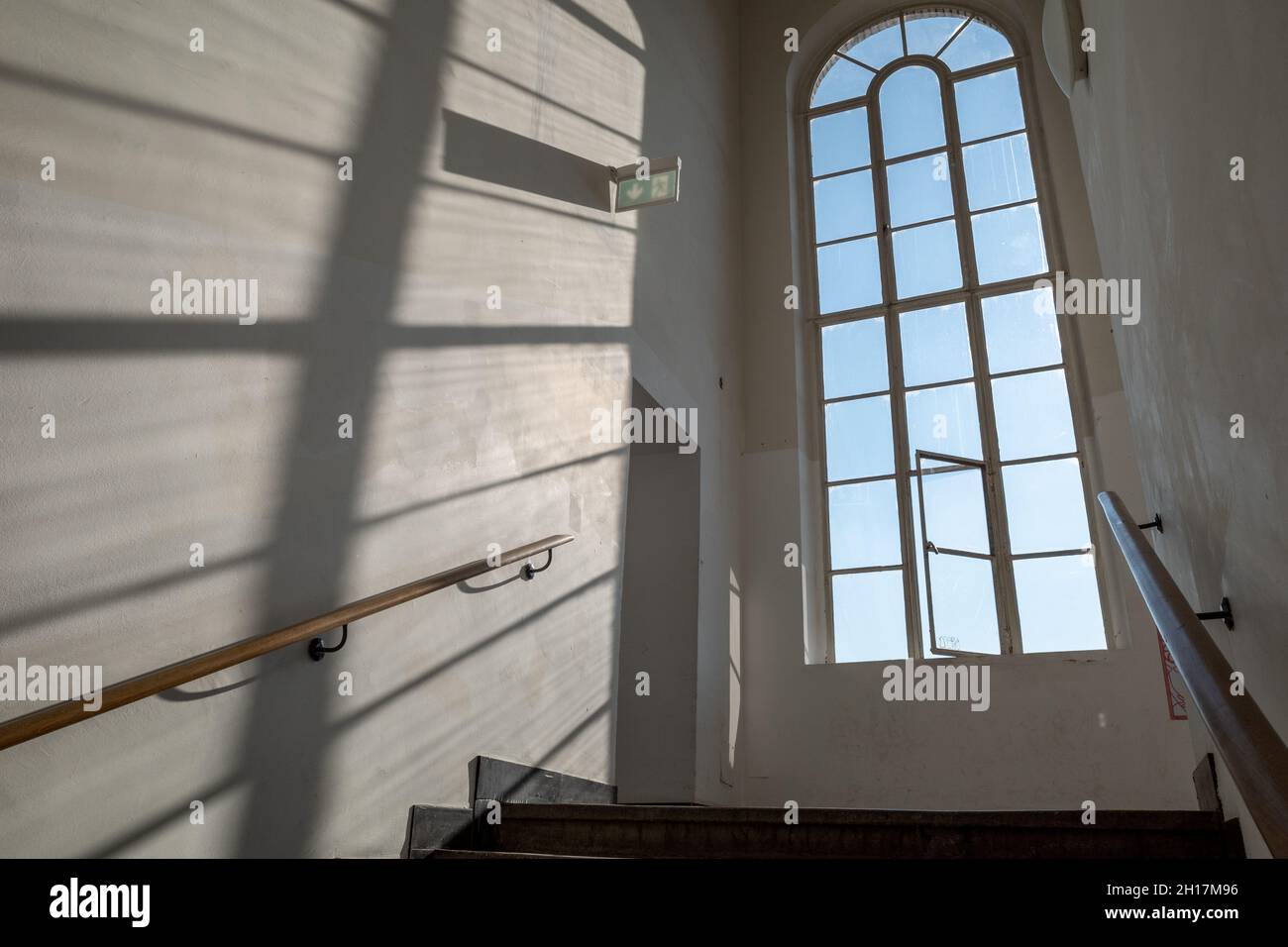 Interior view of staircase with high ceiling, window and natural ...