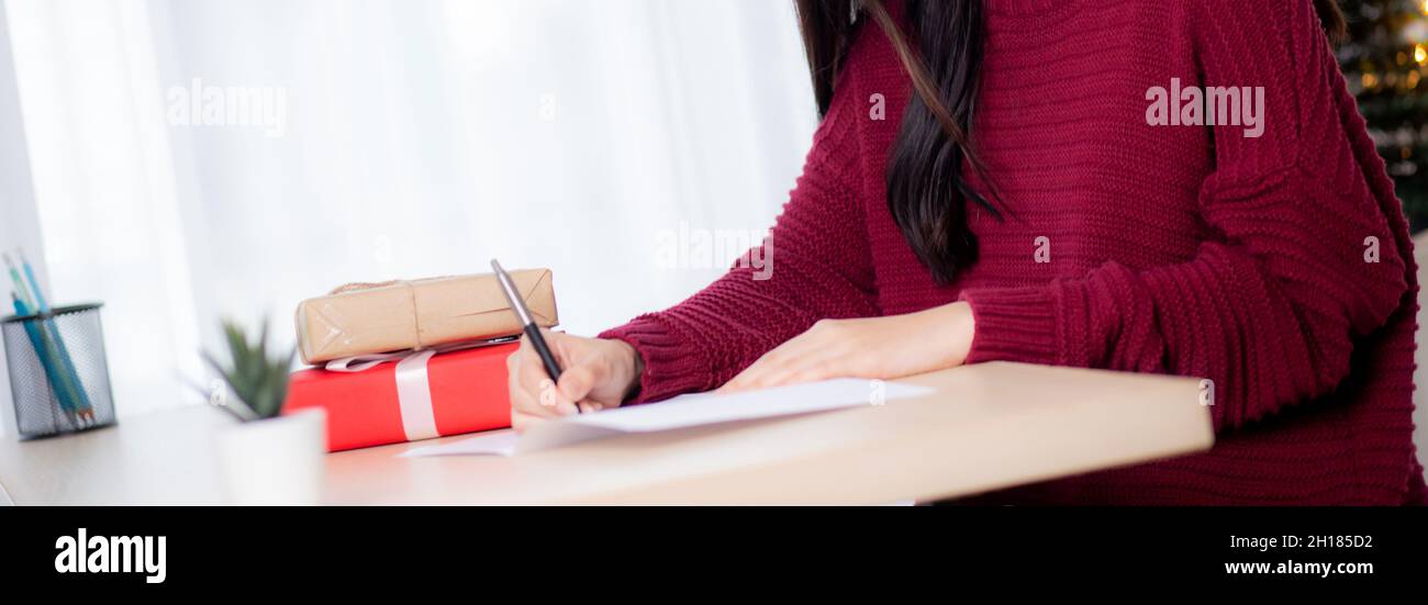 Closeup hand of young asian woman writing postcard in Christmas day at ...