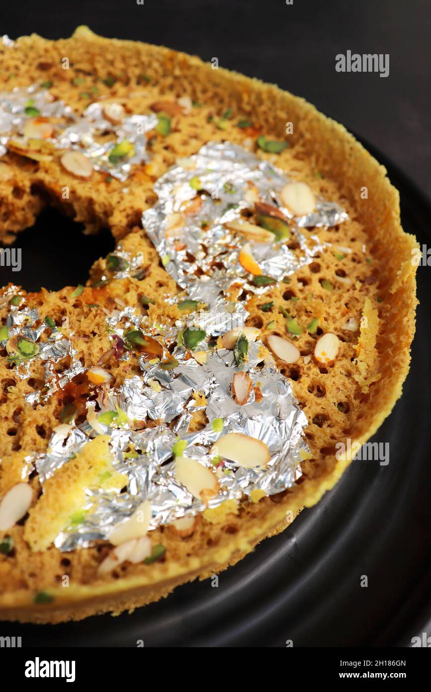Rajasthani Ghevar. Ghewar is an Indian crunchy sweet dish made using ...