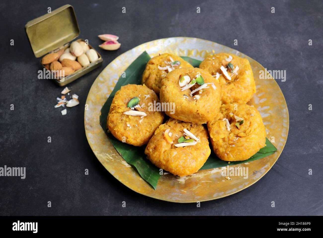Indian traditional sweet balushahi served on a metal plate over black ...