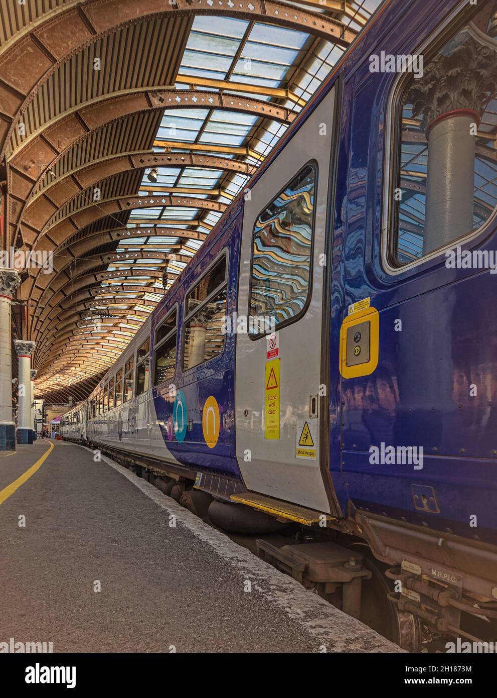 The carriages of a train at a station platform with an historic canopy ...