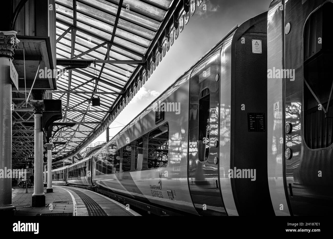 The carriages of a train at a station platform with an historic canopy ...