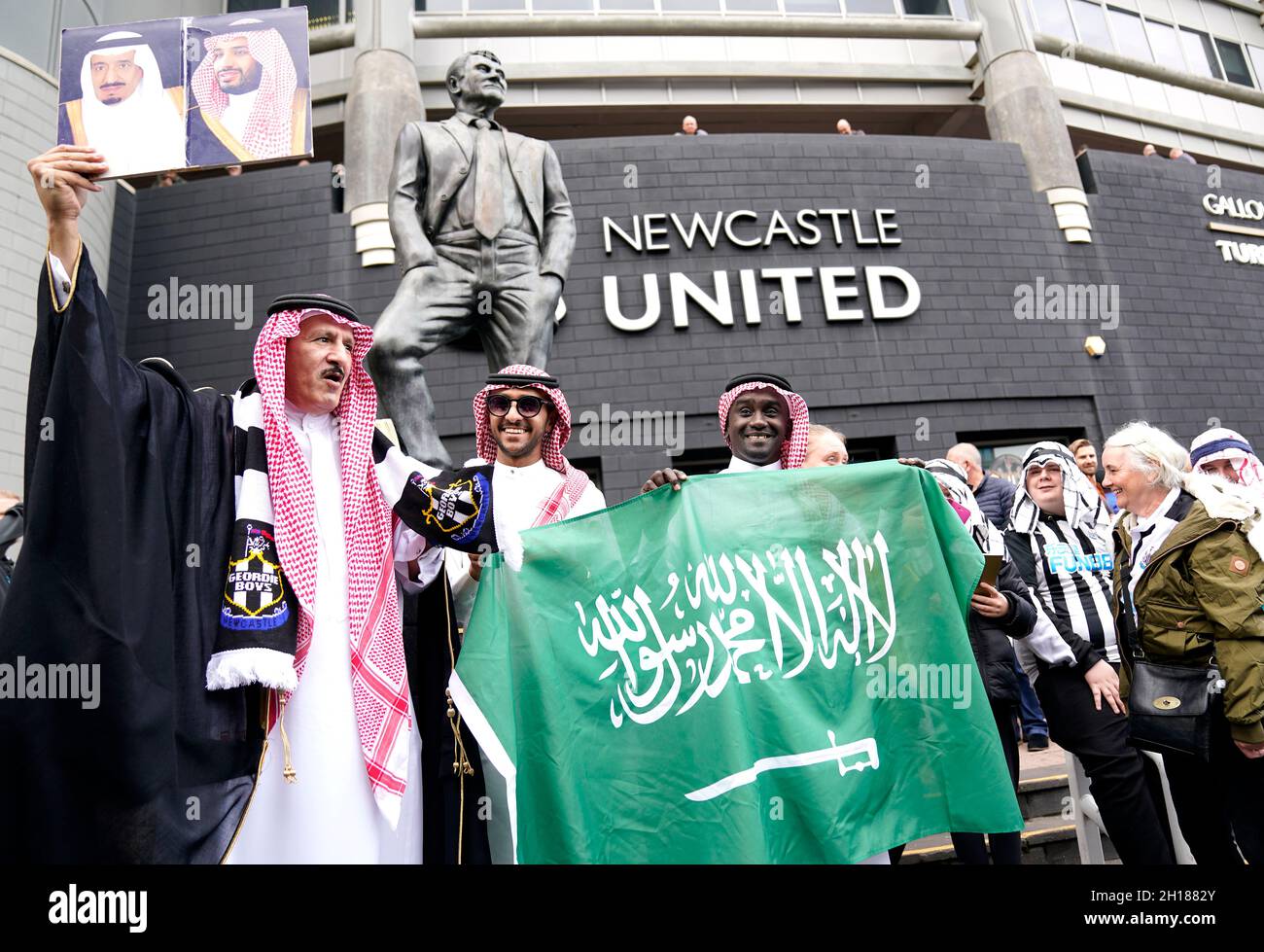 Newcastle United fans outside the stadium hold up a Saudi Arabia flag ...