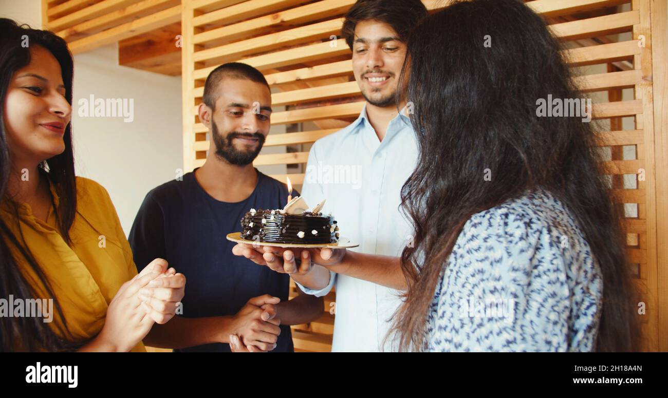 A shot of four South Asian friends in India celebrating a birthday with ...
