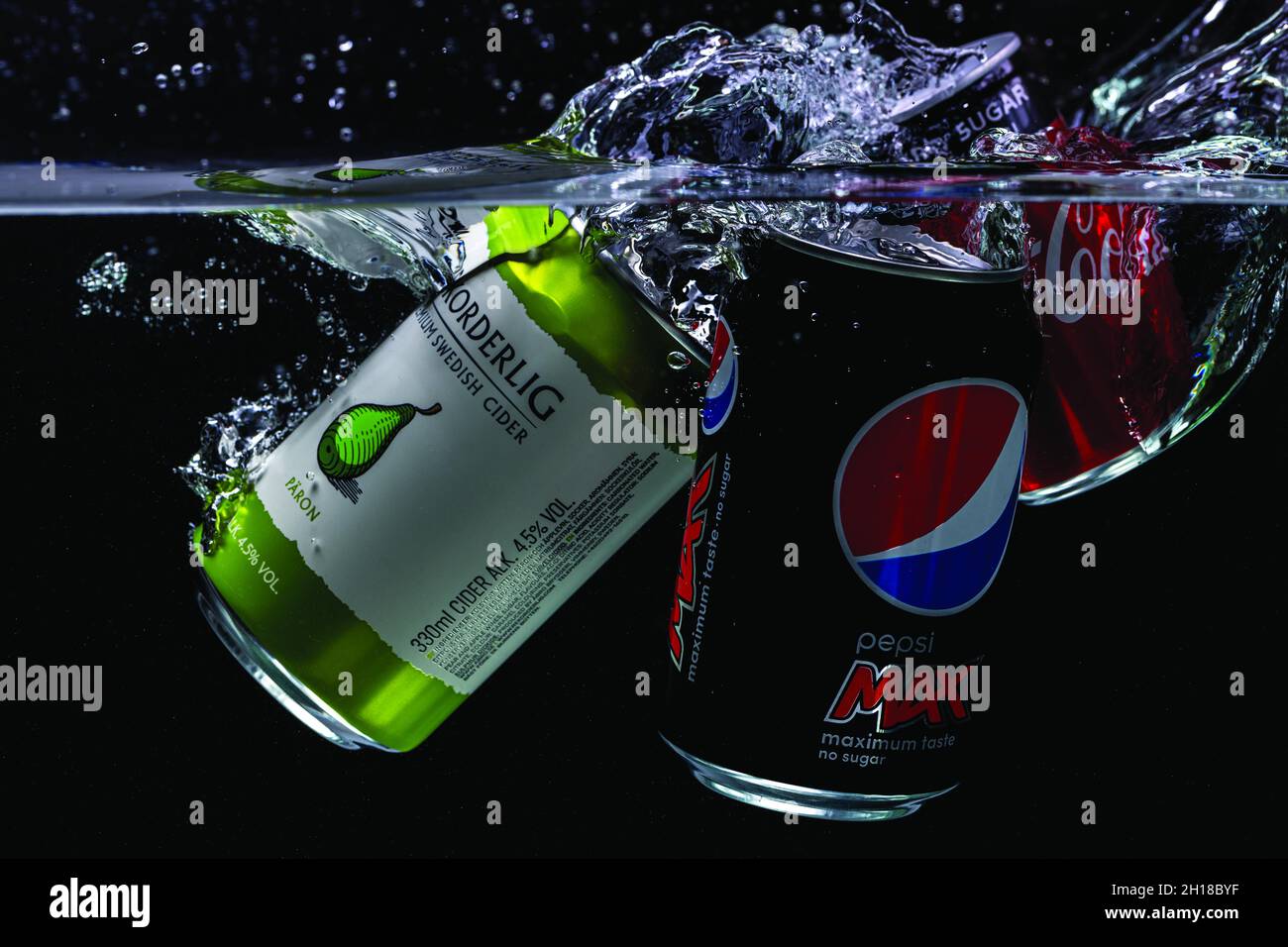 Close up view of three cans falling in water. Coca cola vs Pepsi cola ...