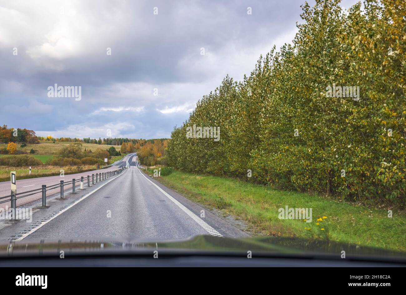 Beautiful view from front window of a car on highway on an autumn day ...