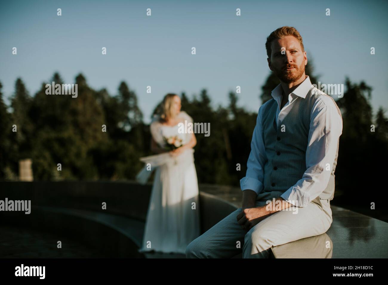 Closeup of the young newlywed man sitting in front of his young bride ...