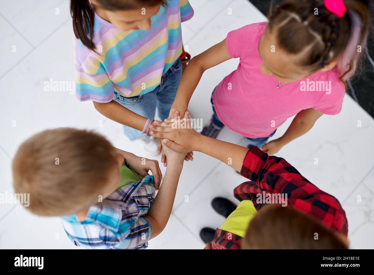 Children hold hands on playground, top view Stock Photo - Alamy