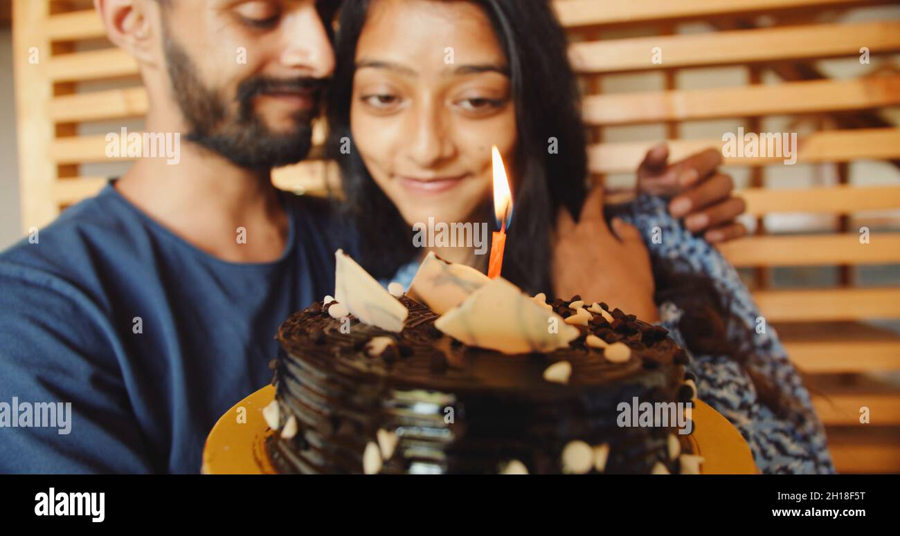 A shot of two young South Asian friends in India with a candled ...