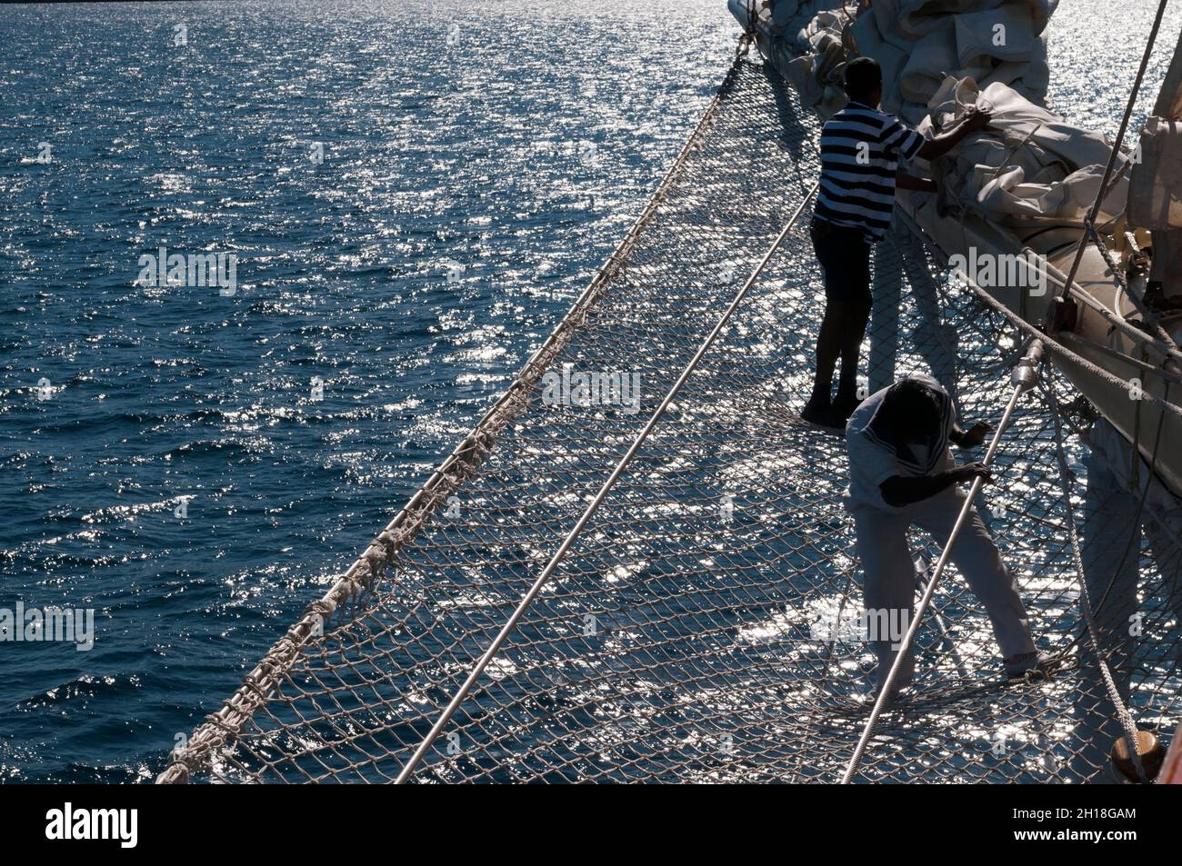 Star Clipper cruise ship passengers traverse netting at the bow of the ...