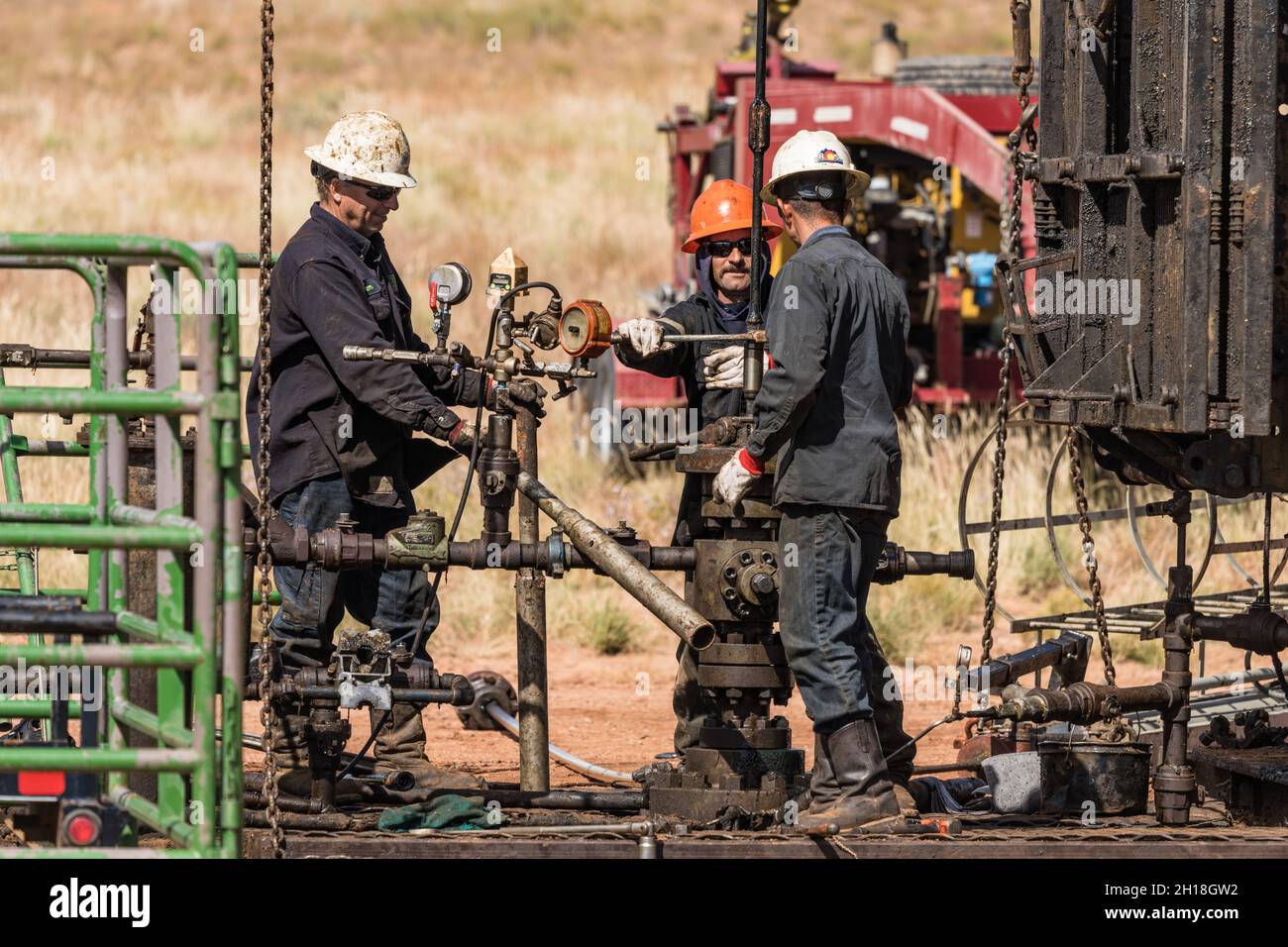 The well service crew on a workover rig works on an oil well to try to ...
