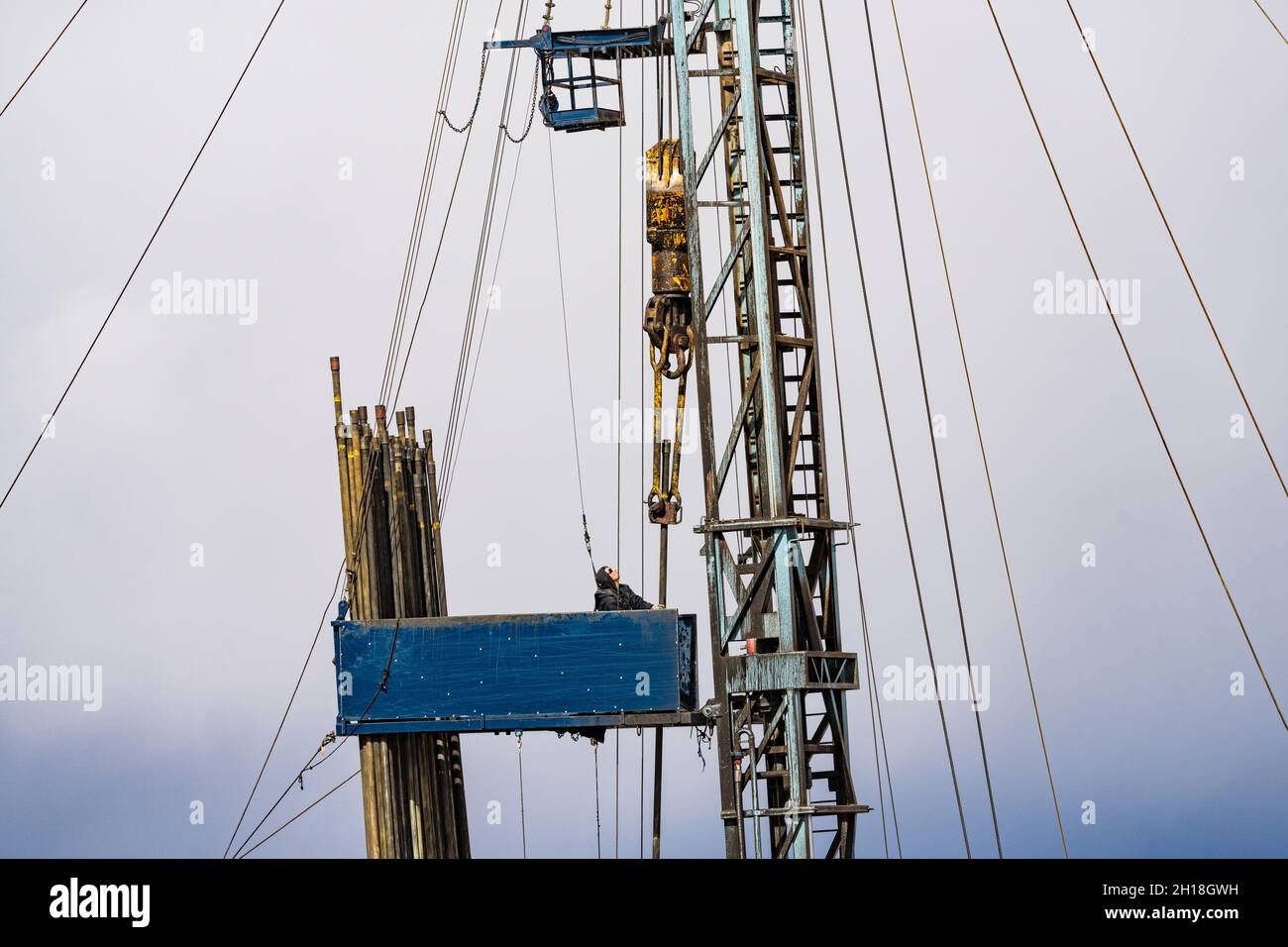 A derrickman or derrickhand on the tubing board of a workover rig on an ...