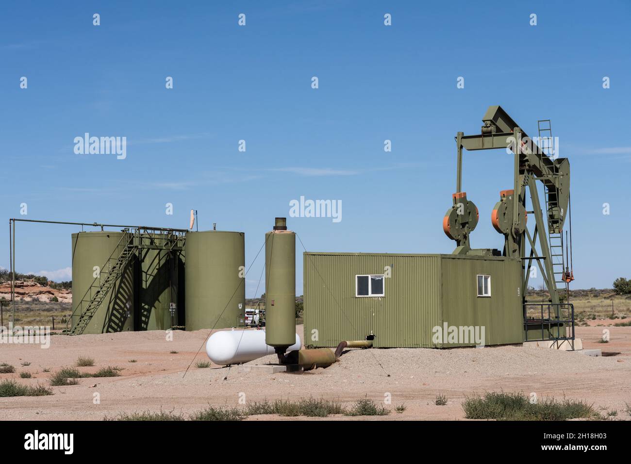 A conventional oil well pump jack unit and storage tank battery on an ...