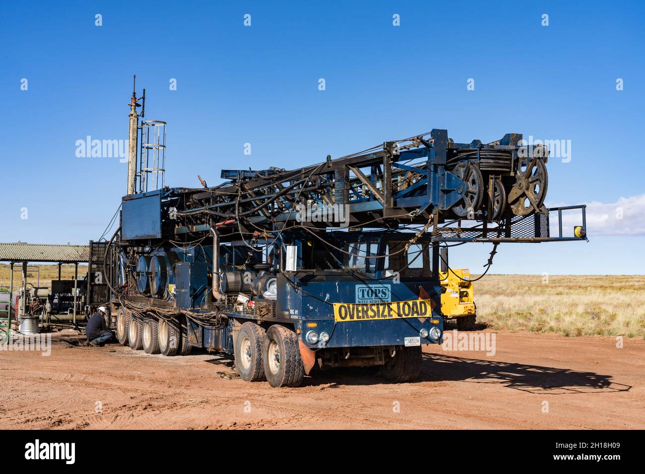 A telescoping truck-mounted workover rig folded down prior to setting ...