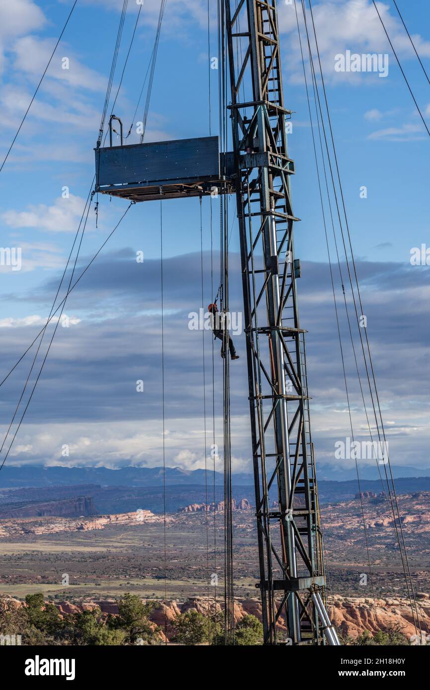 The derrickman being lowered to the ground by his safety harness on an ...