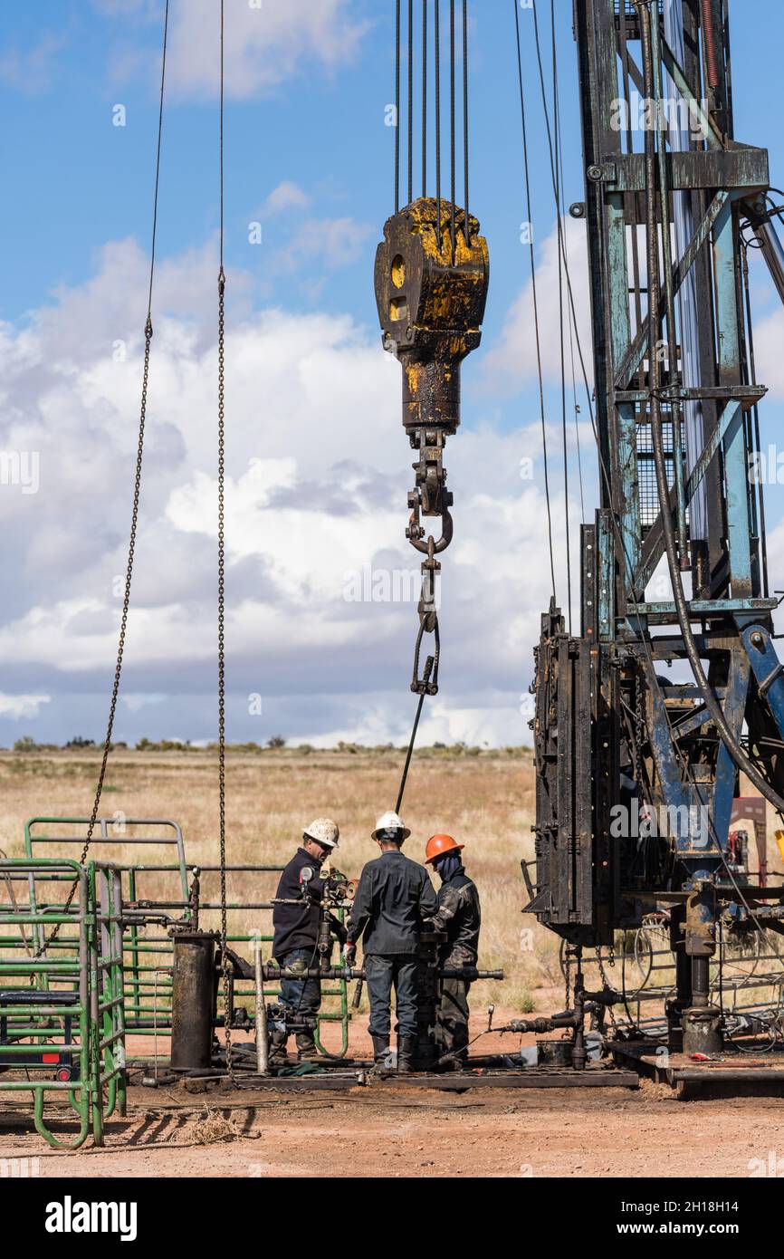 The well service crew on a workover rig works on an oil well to try to ...
