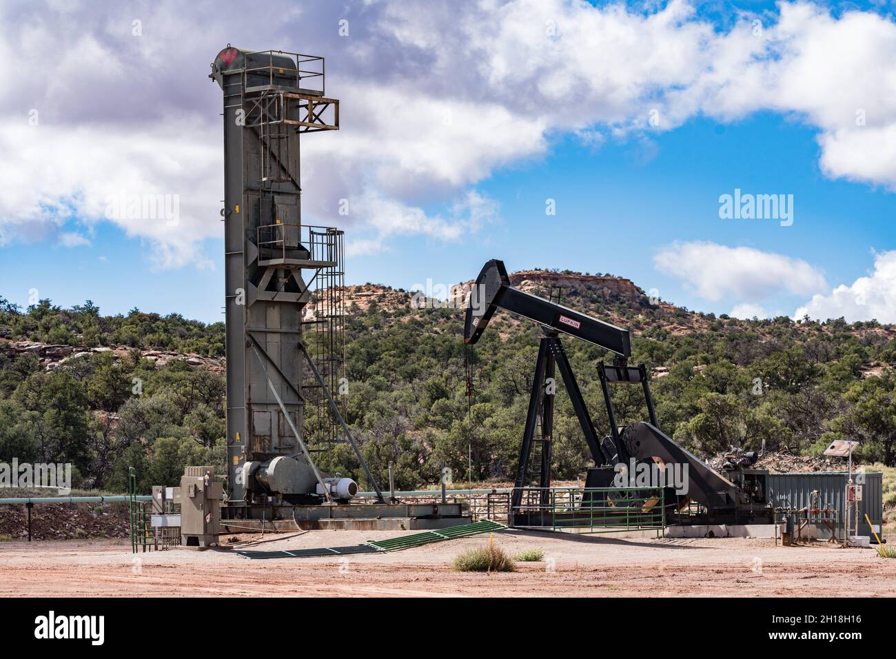 A long stroke belt pump and a traditional pump jack on adjacent oil ...