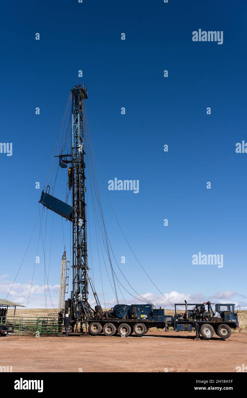 A telescoping truck-mounted workover rig telescoping up to full length ...