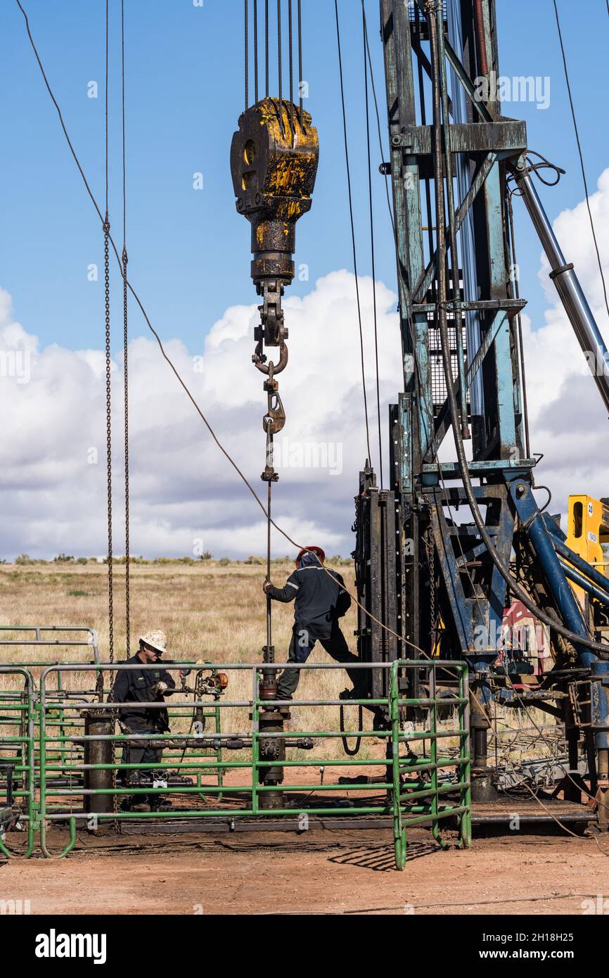 The well service crew on a workover rig works on an oil well to try to ...