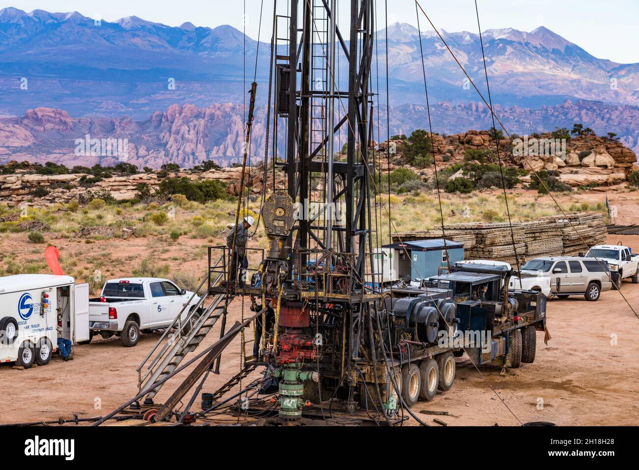 The well service crew on a pulling unit or workover rig works on an oil ...
